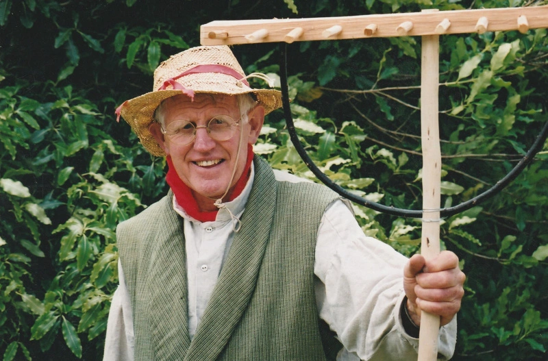 Alan la Roche (in costume) holding a rake in Howick Historical Village ...