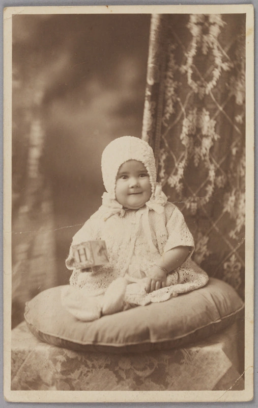 Photograph, Infant wearing a bonnet | Record | DigitalNZ