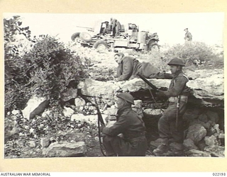 EL GAZALA, LIBYA. 1941-12. NEW ZEALANDERS CROUCHED UNDER COVER BEFORE ...
